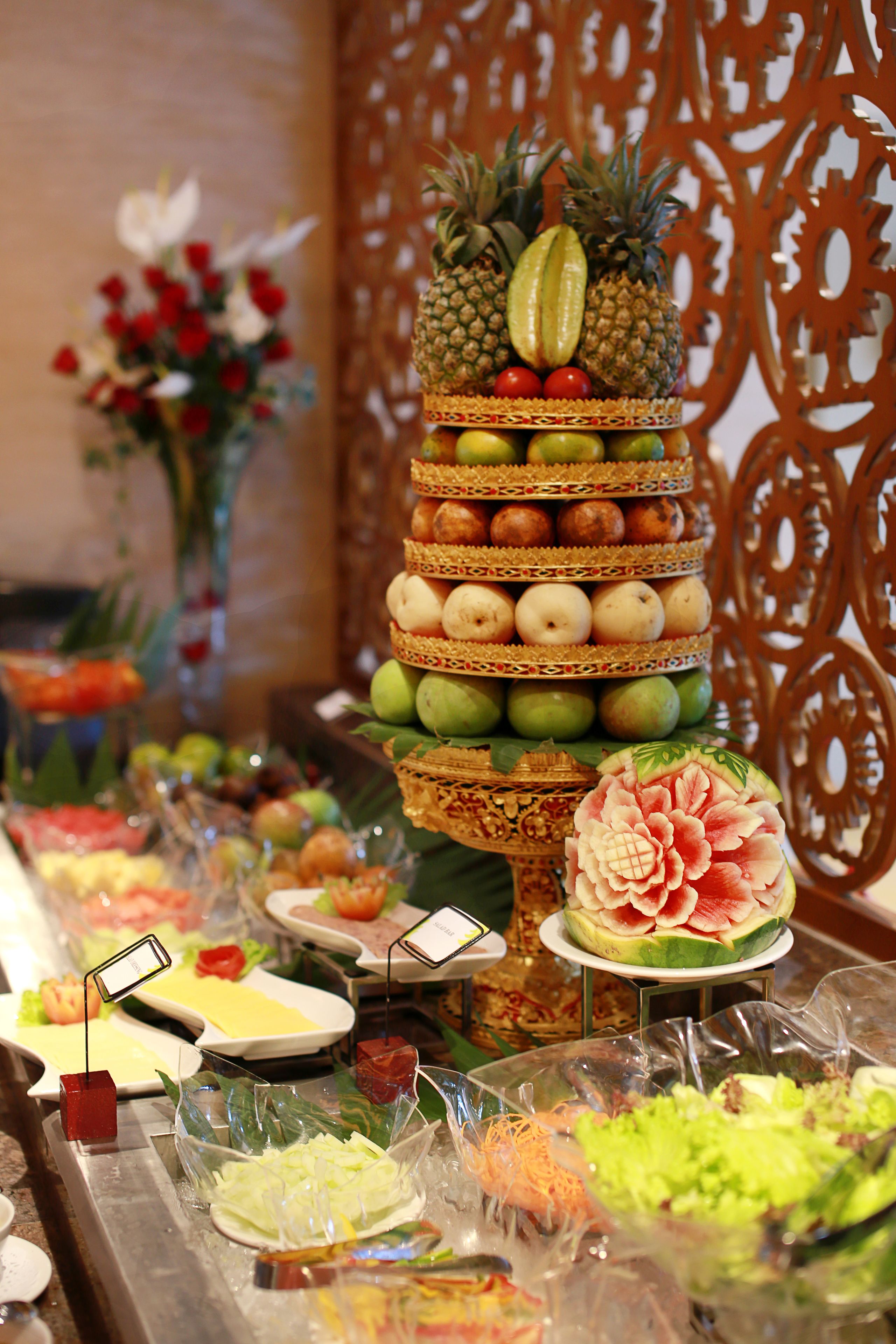 Buffet com diversas opções de comida, incluindo frutas, legumes e saladas.