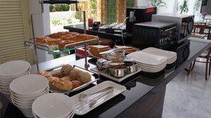Uma mesa de buffet com diversos alimentos e utensílios de servir.
