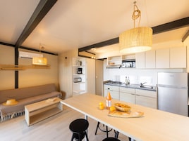 Cozinha moderna com ilha central, eletrodomésticos embutidos e luminária pendente.