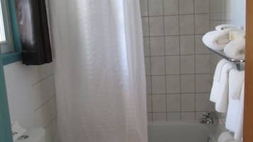 Um banheiro com banheira, vaso sanitário e cortina de chuveiro.