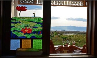 Uma área de refeições com uma mesa posta para dois, com vista para uma paisagem montanhosa.