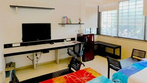 Um espaço de escritório moderno com uma mesa, cadeira, computador e janela com persianas.