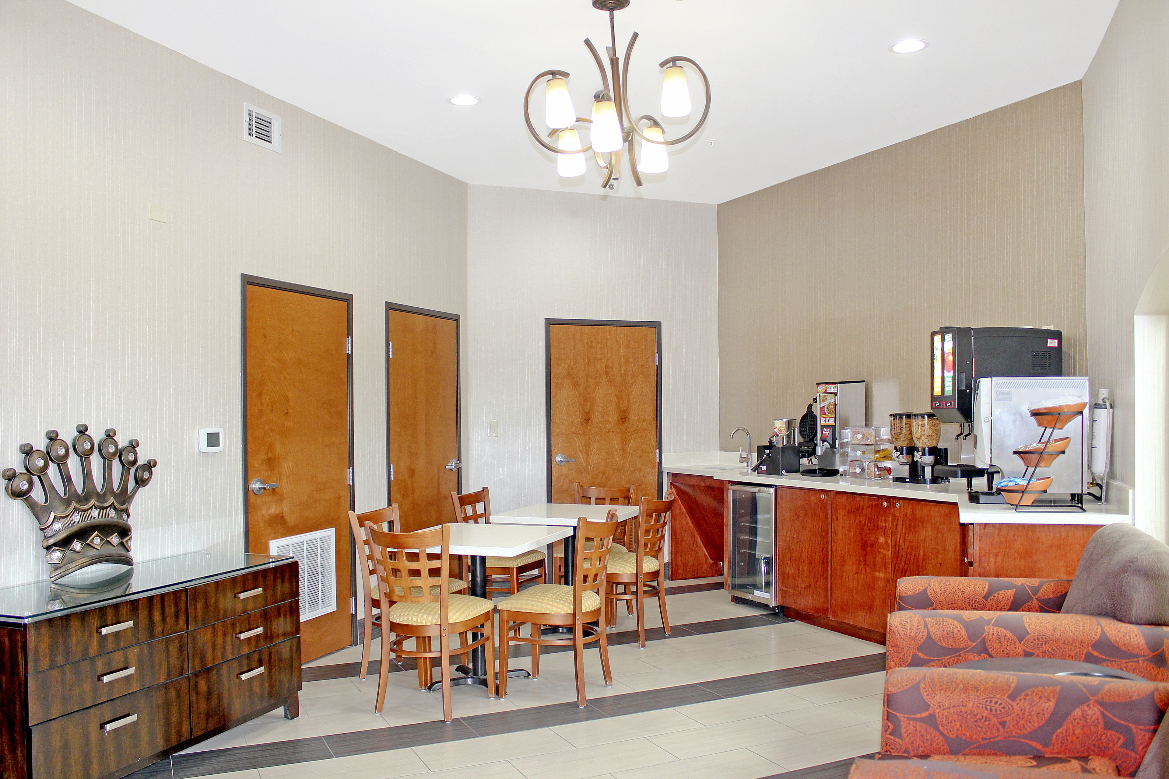 Quarto de hotel com área de refeições, cozinha compacta e sala de estar.
