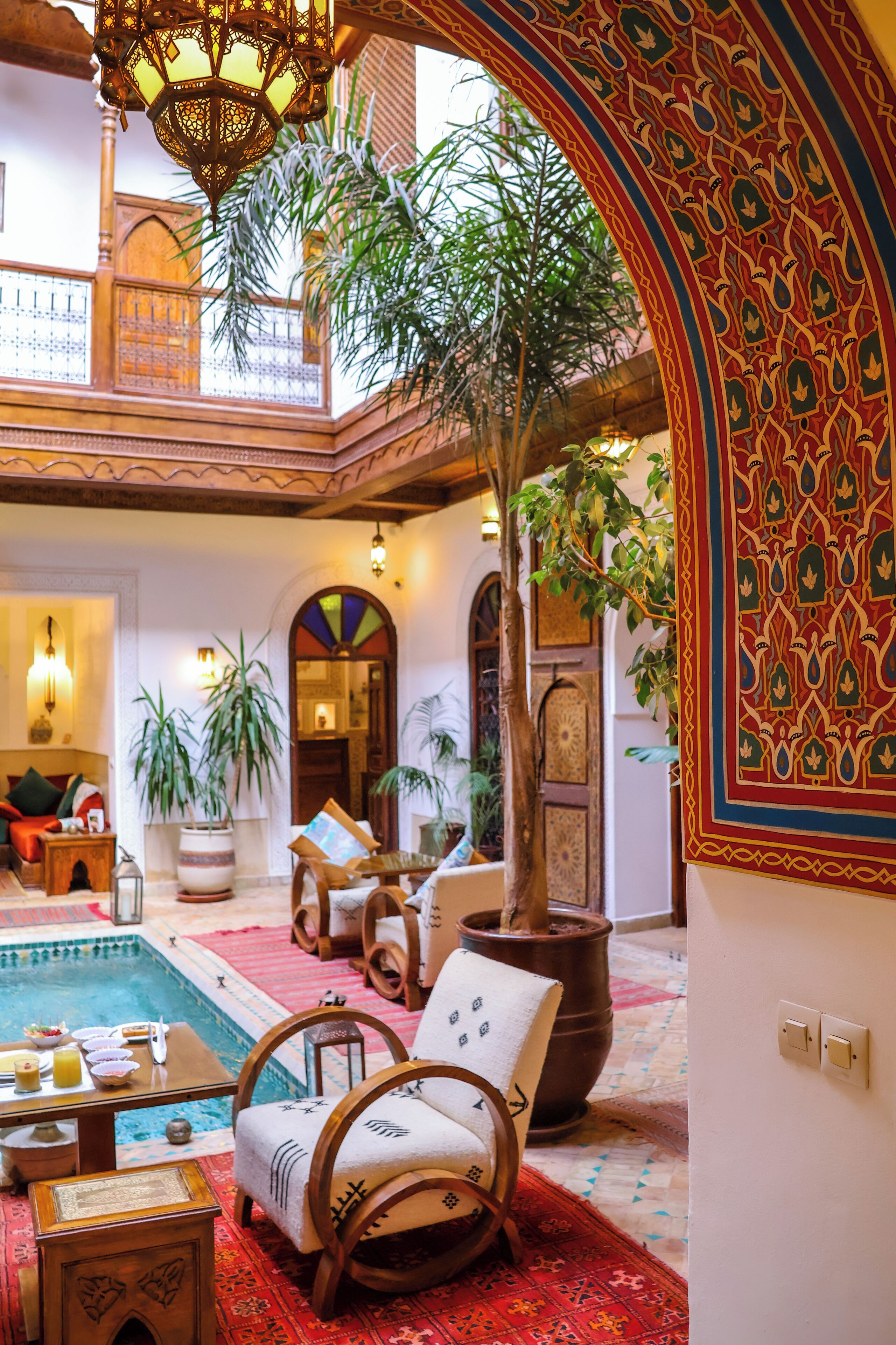 Um ambiente interno luxuoso com piscina, assentos confortáveis e detalhes decorativos.