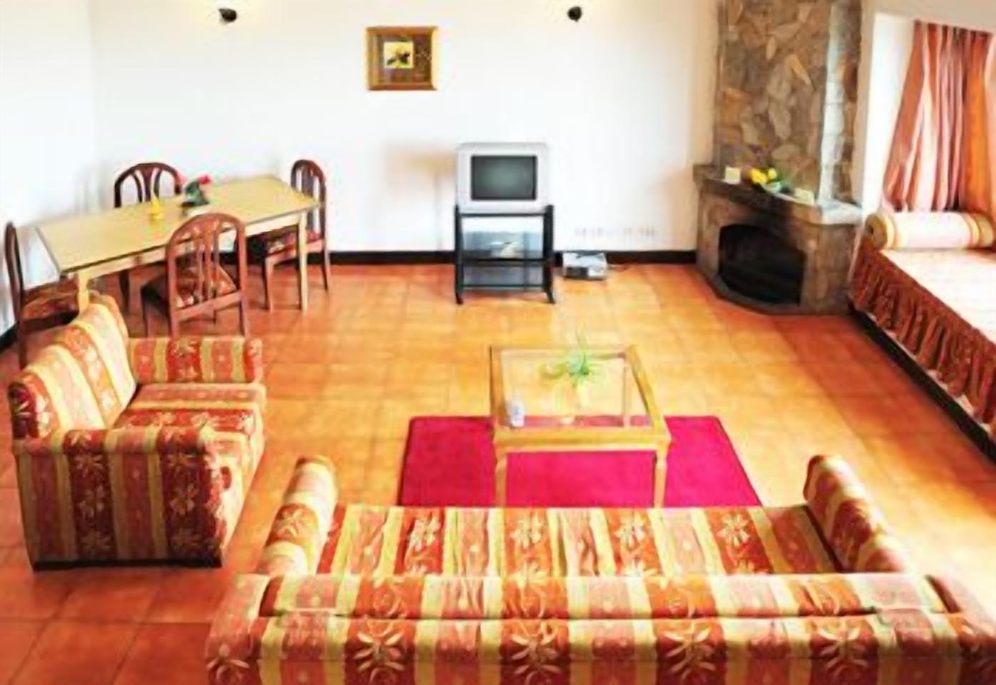 Uma sala de estar com sofá, mesa de centro e lareira.