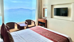 Quarto de hotel com uma cama, televisão, secretária e cadeira.