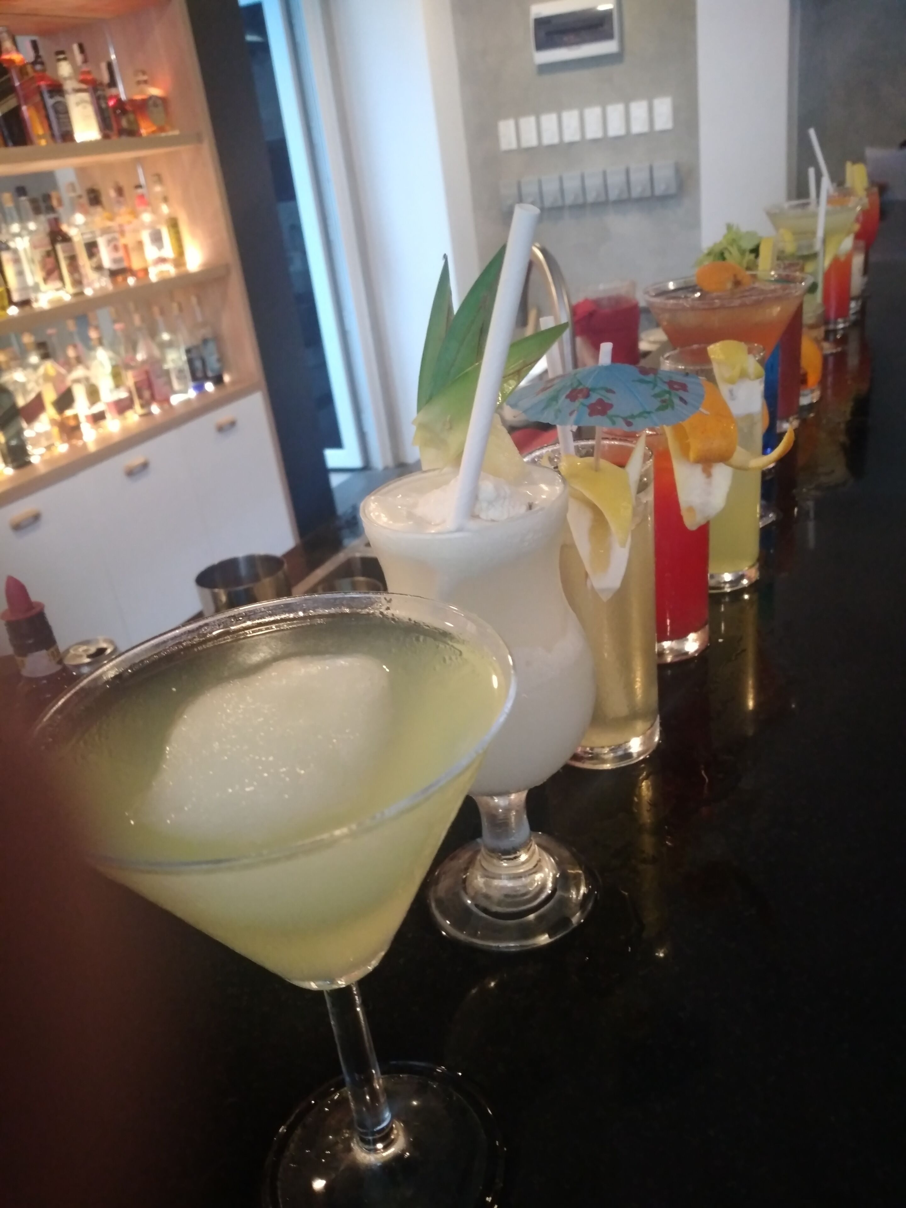 Uma área de bar com diversas bebidas e uma estante de garrafas.