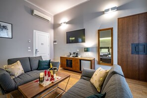 Suíte estúdio luxo, 1 cama King | Área de estar | TV de tela plana 55 polegadas com canais via satélite, TV