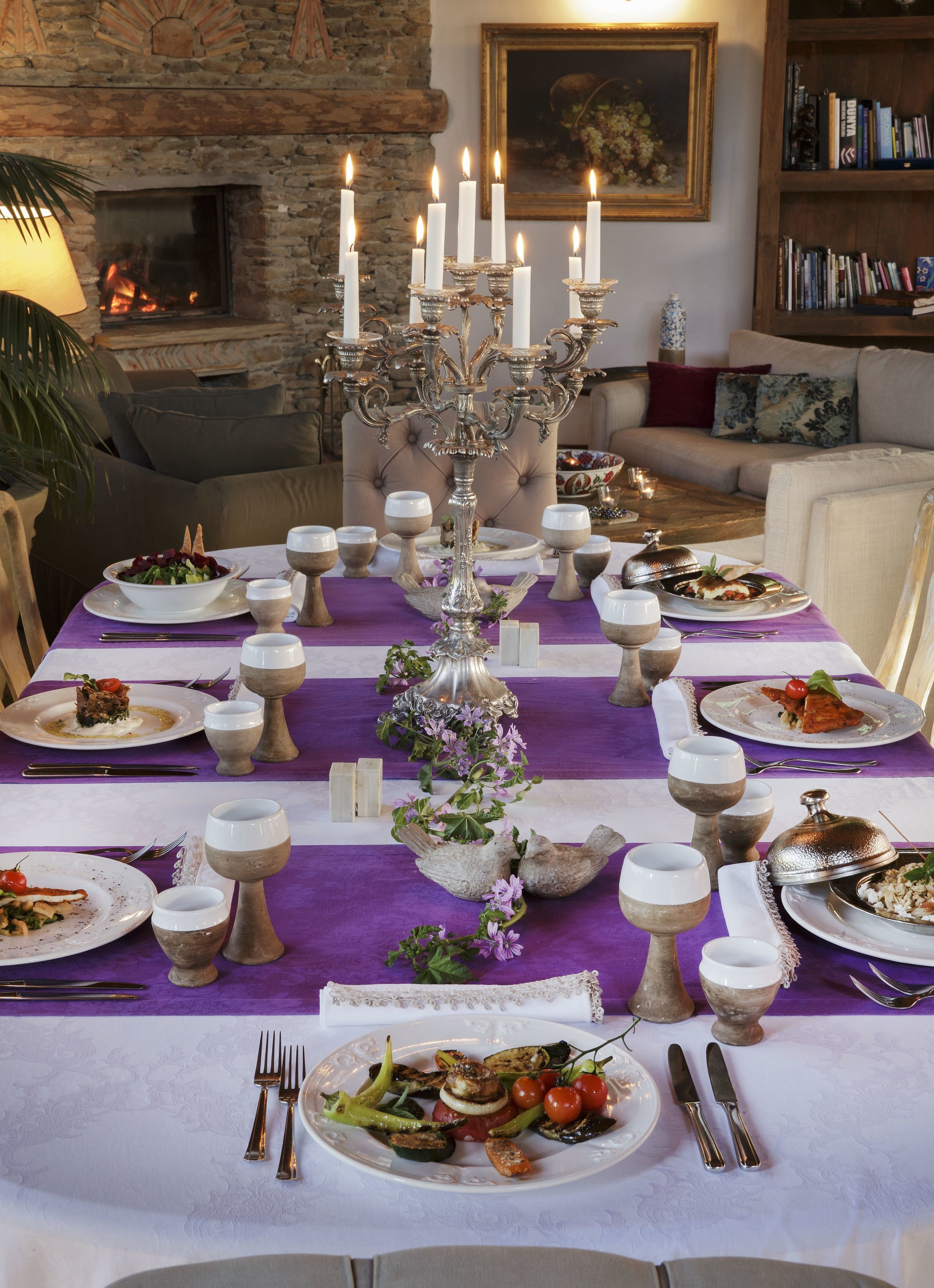 Uma mesa de jantar posta com pratos de comida, velas e um candelabro.