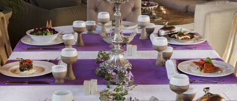 Uma mesa de jantar posta com pratos de comida, velas e um candelabro.