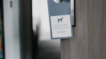 Uma porta com um aviso de bem-vindos a animais de estimação e uma portinhola para animais.