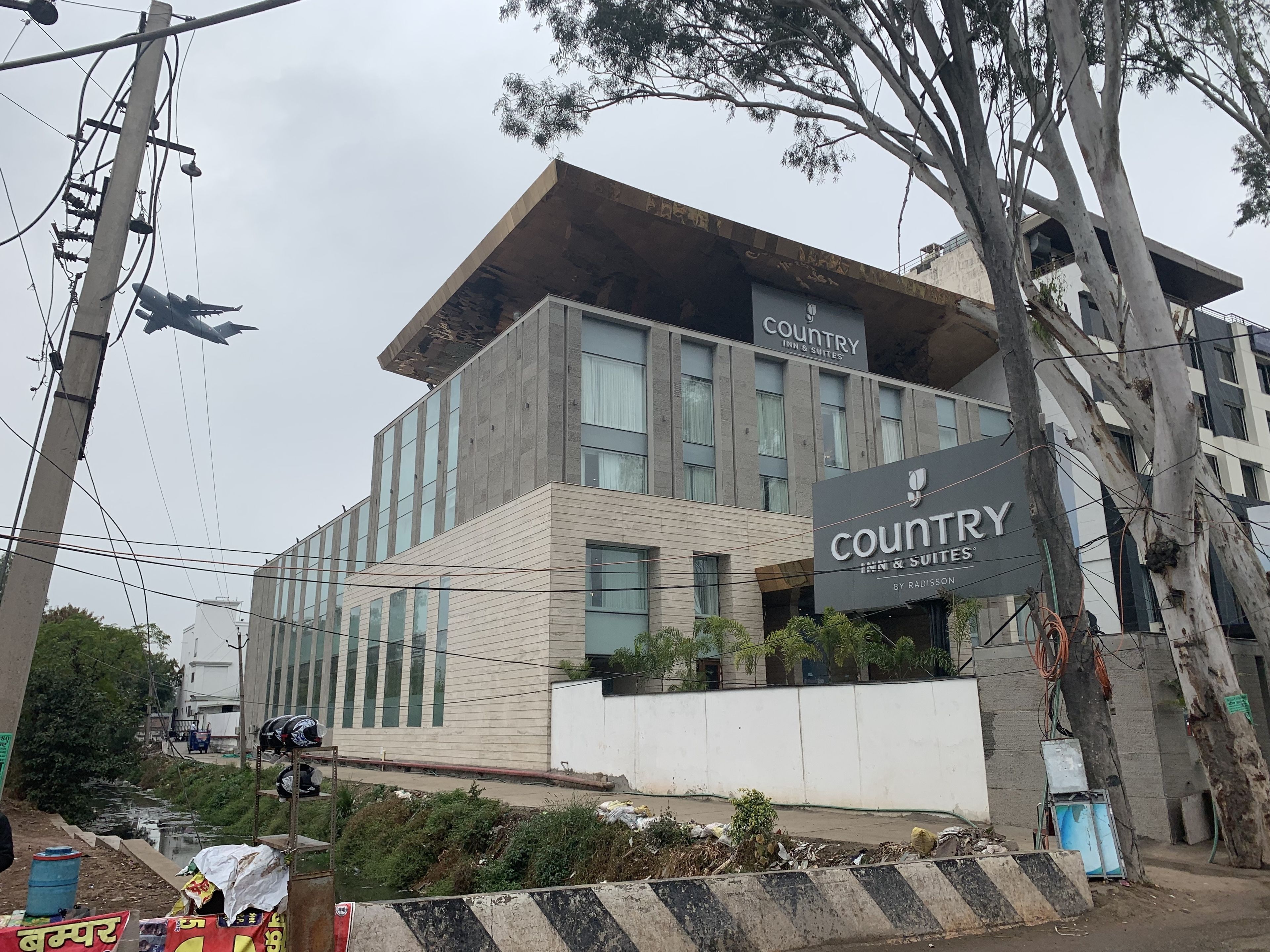 Um edifício moderno com uma placa indicando 'Country Inn & Suites' by Radisson. Possui um telhado plano, janelas amplas e fachada branca.