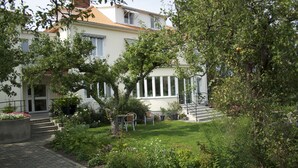 Uma casa com jardim, escada e porta.