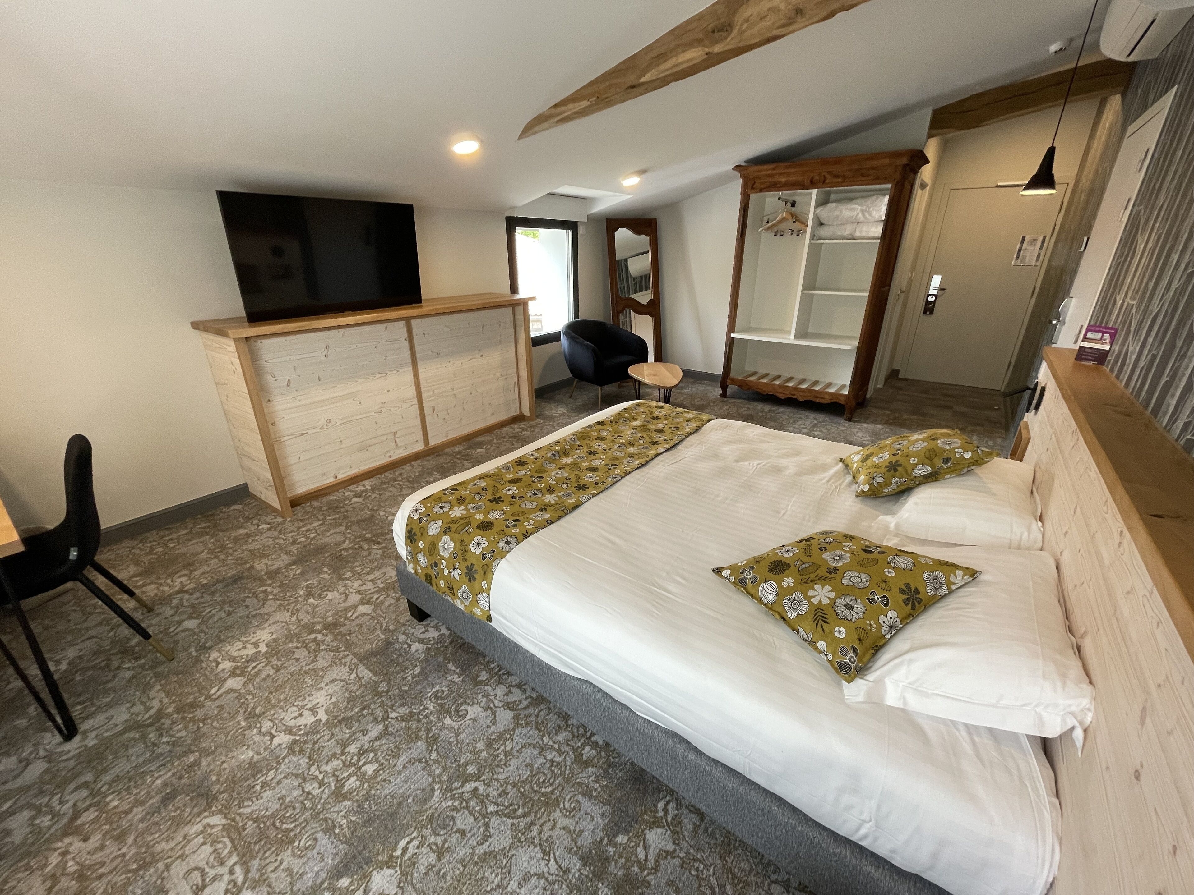 Quarto com cama, escrivaninha, cadeira, guarda-roupa e televisão.
