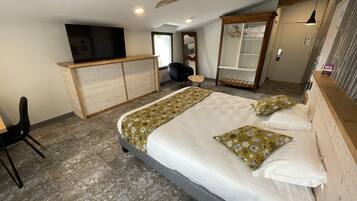 Quarto com cama, escrivaninha, cadeira, guarda-roupa e televisão.