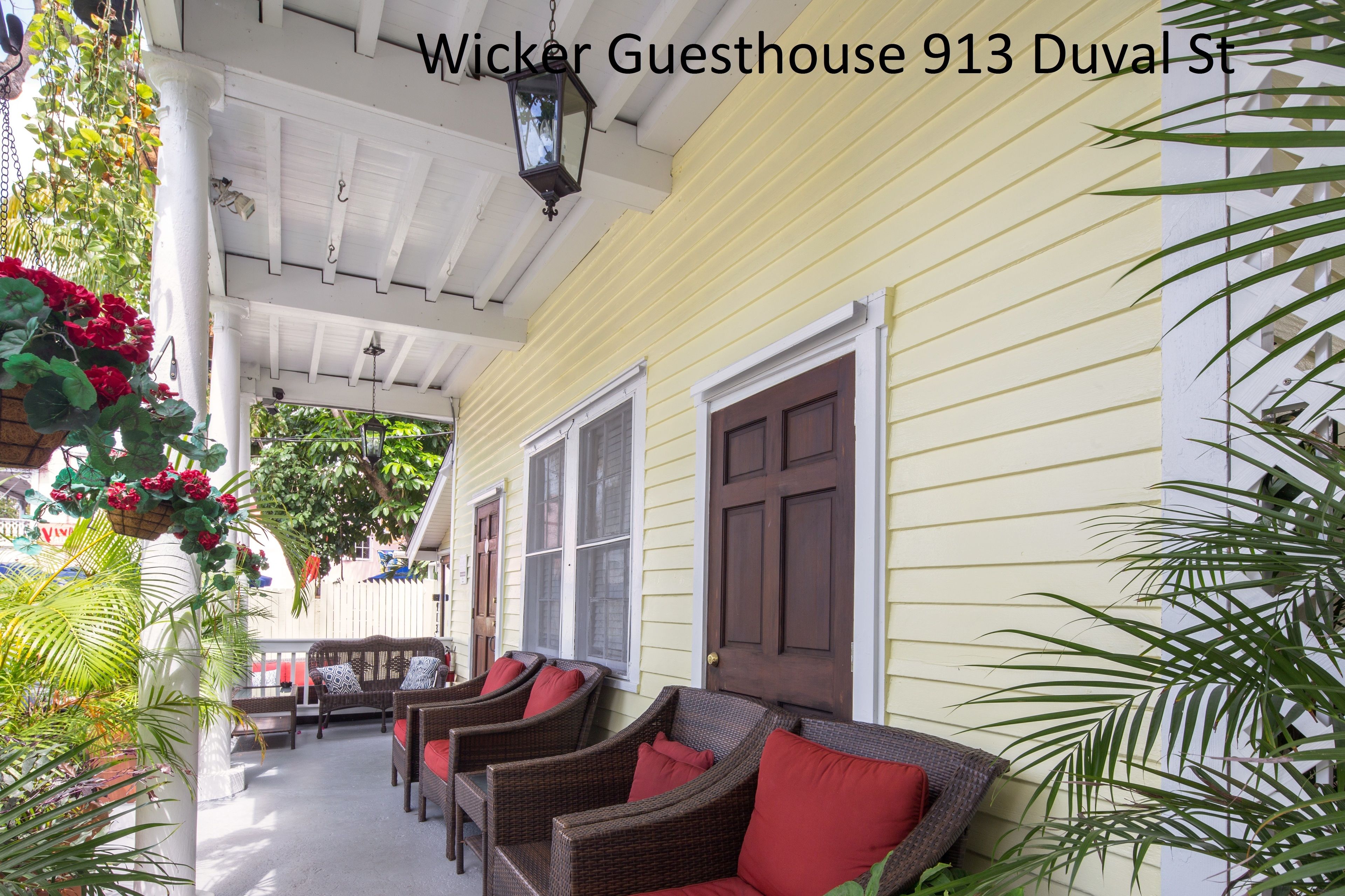 Varanda com móveis de vime e almofadas vermelhas na Wicker Guesthouse, 913 Duval St.
