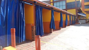 Cortinas azuis cobrem a entrada de um edifício com paredes amarelas e laranjas.