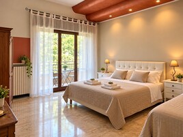 Quarto de hotel com cama, mesas de cabeceira, vista através de uma porta de vidro e um vaso com planta.