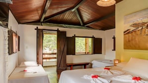 Quarto com duas camas de solteiro, teto de madeira, um quadro na parede e janela com vista para o verde.