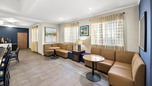Uma sala de estar moderna com um conjunto de sofá, uma mesa de jantar e duas mesinhas redondas.