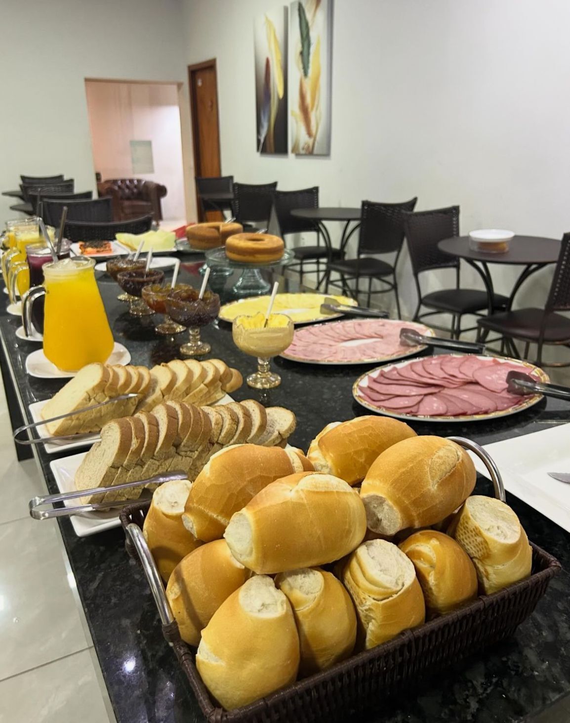Buffet com pão, pastelaria e diversas bebidas.