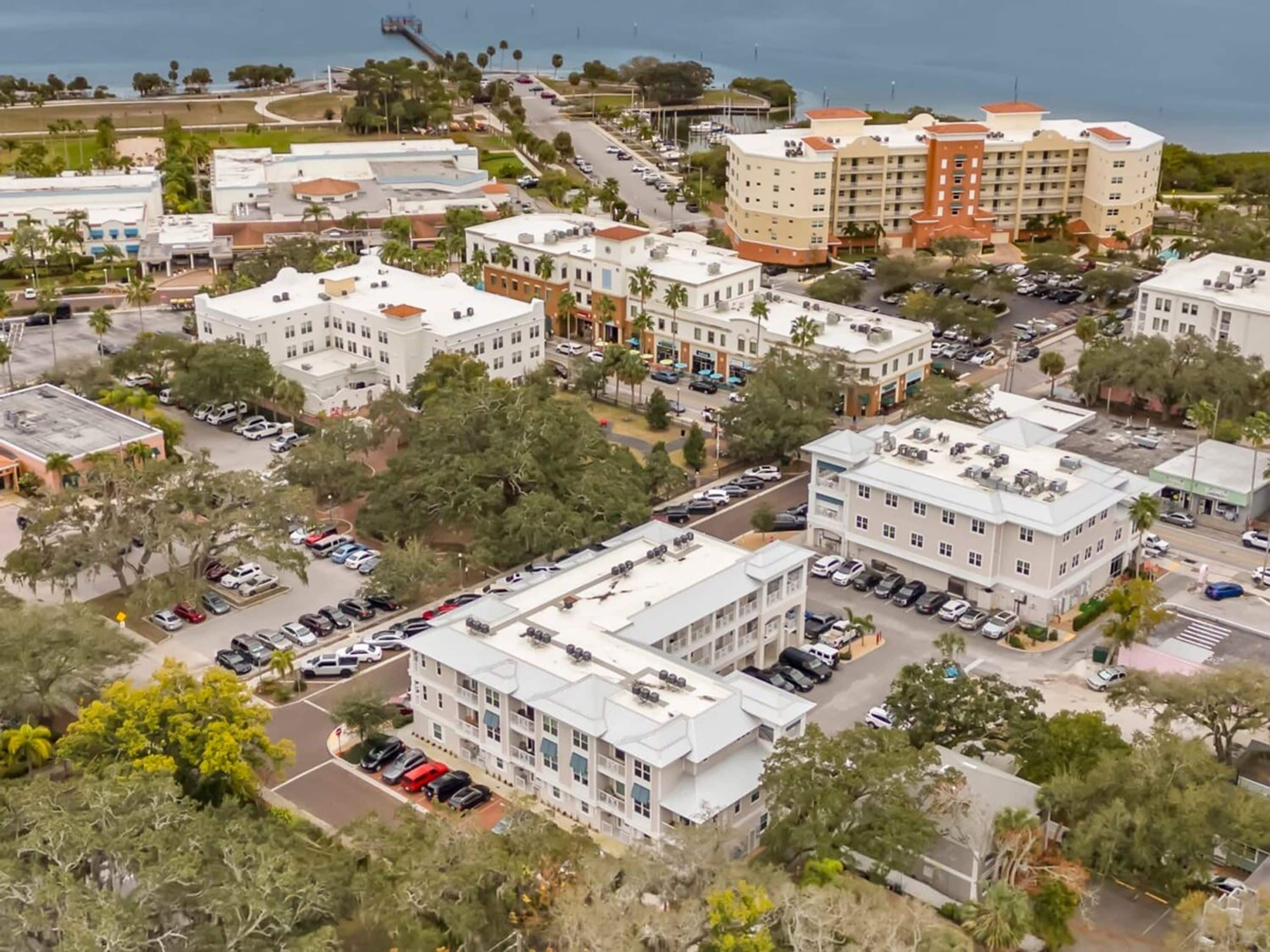 Uma área urbana costeira com uma combinação de edifícios comerciais e residenciais, incluindo um hotel notável com vários andares e estacionamento.