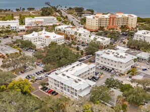 Uma área urbana costeira com uma combinação de edifícios comerciais e residenciais, incluindo um hotel notável com vários andares e estacionamento.