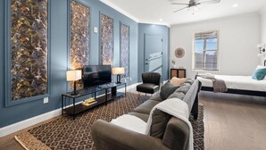 Uma sala de estar moderna com sofá, TV e arte decorativa na parede.