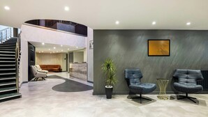 Um lobby moderno com escadaria, área de estar e planta.