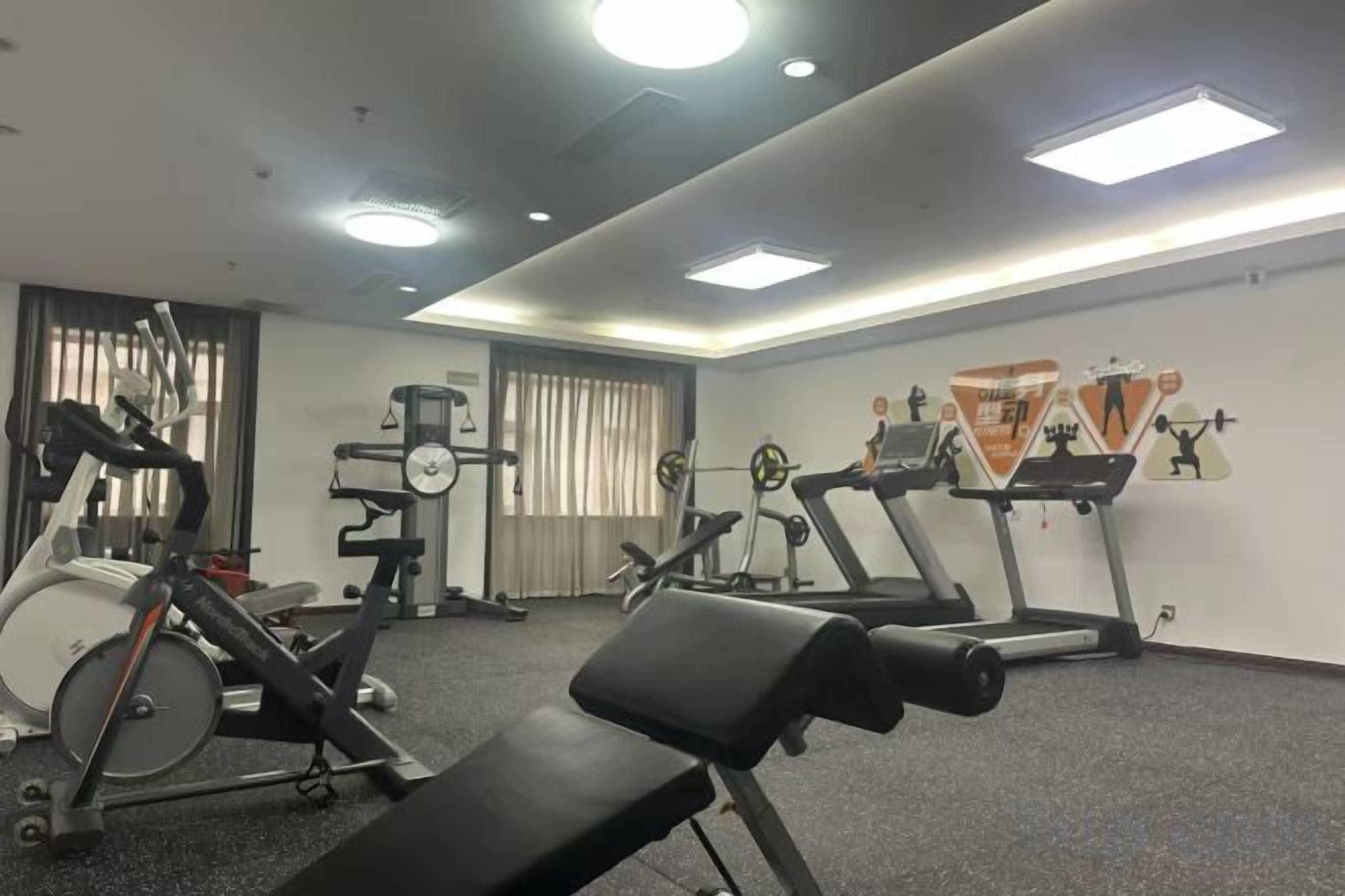Uma academia com diversos equipamentos de exercício, incluindo esteiras, bicicleta ergométrica e aparelhos de musculação.