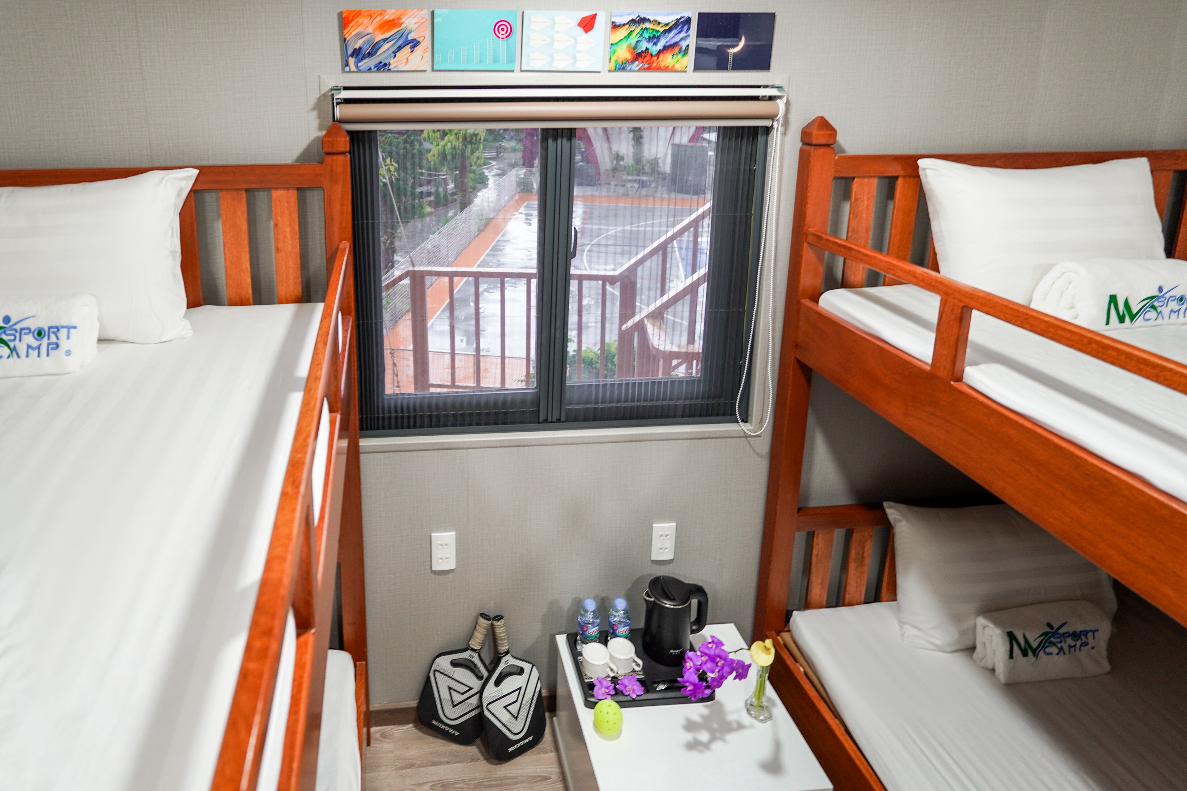 Quarto com beliche, janela, uma mesinha com produtos de higiene e um par de sapatos.