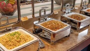 Buffet com várias estações de comida, incluindo um bar de saladas e uma estação de macarrão.