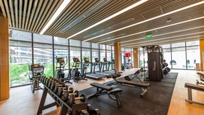 Uma academia moderna com esteiras, bancos de musculação e halteres.