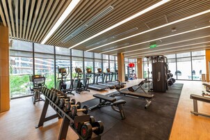 Uma academia moderna com esteiras, bancos de musculação e halteres.