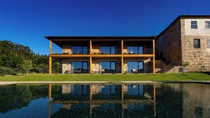 Uma casa de dois andares com piscina na frente.