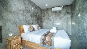 Quarto com cama de madeira, mesa de cabeceira e ar-condicionado fixado na parede.