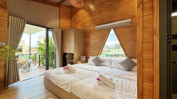 Quarto com uma cama grande, paredes de madeira, uma janela e vista para o exterior.