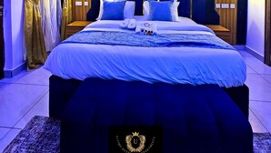 Um quarto moderno com uma cama grande, duas mesas de cabeceira e uma mesinha de apoio.