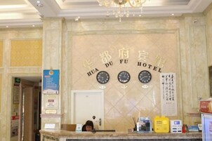 Balcão de recepção de hotel com relógios e uma placa em idioma estrangeiro.