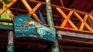 Uma estrutura de madeira com uma placa que diz "The Momo Beach".