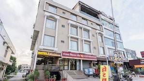 Um hotel com vários andares, entrada no andar térreo, um caixa eletrônico visível e uma placa do Banco Nacional do Punjab.