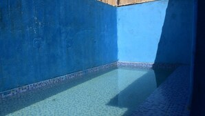 Piscina com paredes azulejadas em azul e fundo transparente também em azul.