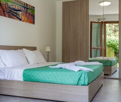 Apartamento Deluxe, 2 quartos, não fumadores, pátio | Edredões de penas, cortinas/cortinados opacos, ferro/tábua de engomar