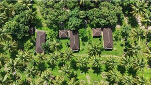 Vista aérea de um resort com três edifícios rodeados por palmeiras.