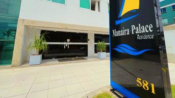 Entrada de um edifício com uma placa indicando "Manaira Palace Residence" e o número "581".