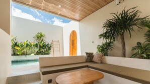 Um interior moderno com uma mesa de madeira, um banco embutido e vista para uma piscina.