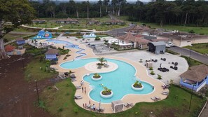Resort com uma piscina grande, áreas de descanso e parque aquático.