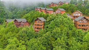 Um conjunto de cabanas de madeira aninhadas em uma área arborizada, com vários níveis e varandas.