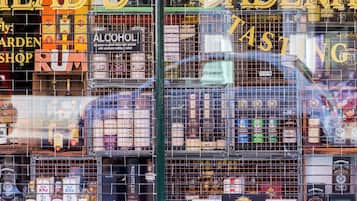 Vitrine de loja exibindo diversas marcas e produtos de bebidas alcoólicas, incluindo rum e gin.