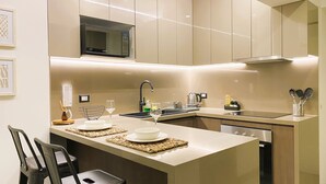 Uma cozinha moderna com ilha central, eletrodomésticos de aço inoxidável e máquina de lavar louça.